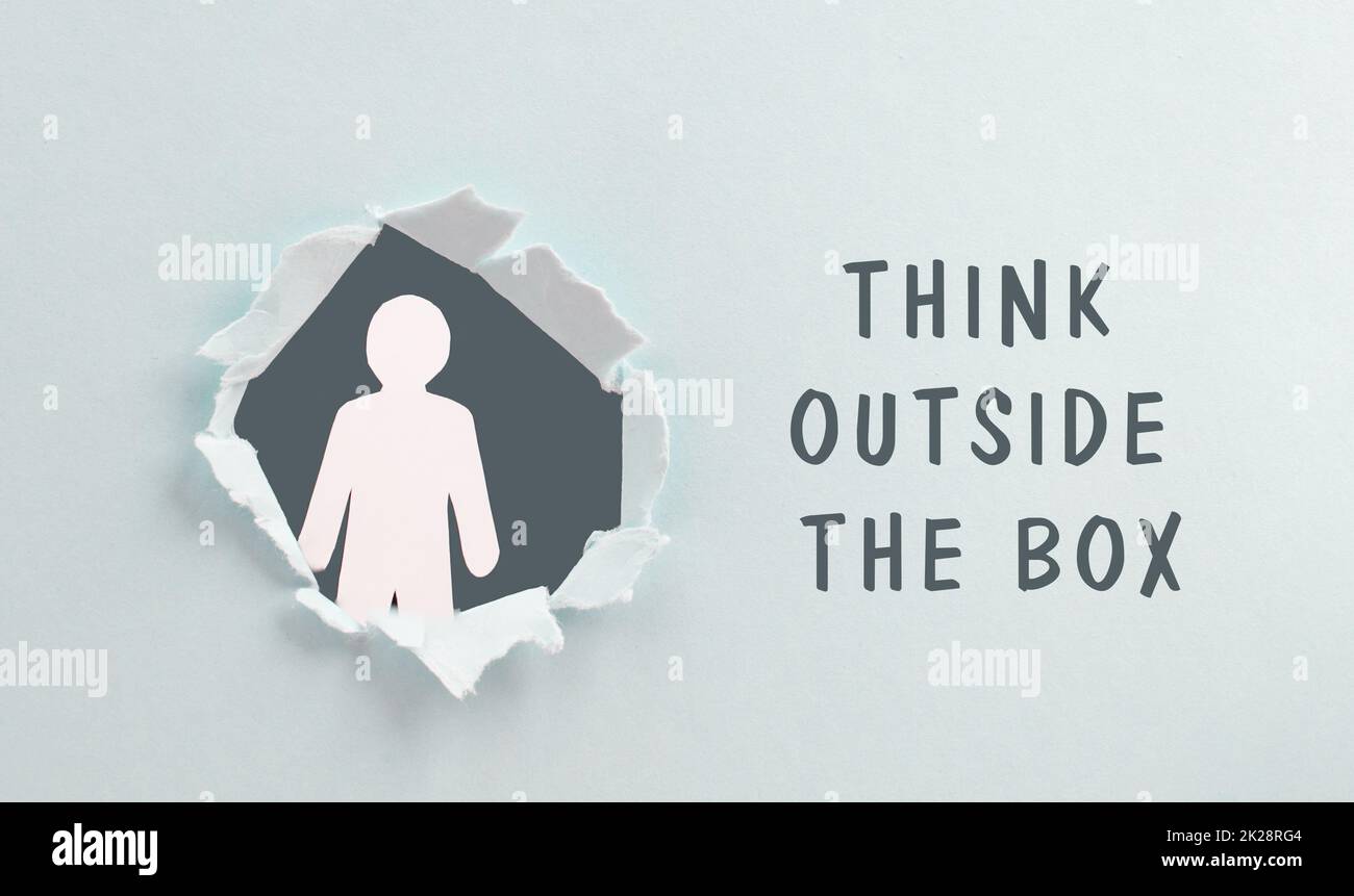 Think outside the box is standing on the torn paper, man is behind an ...