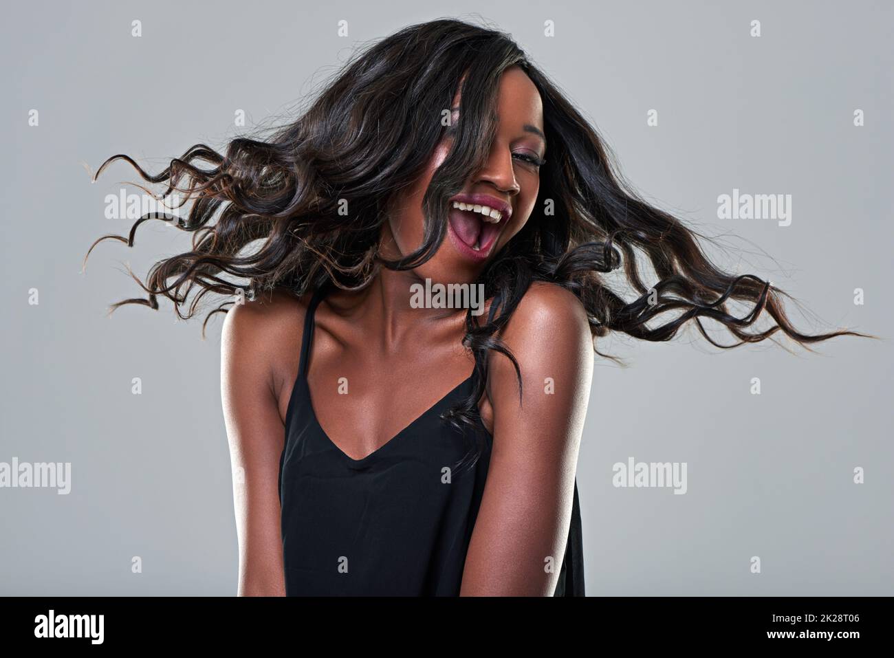 Feeling free. Studio shot of a young woman with beautiful hair isolated ...