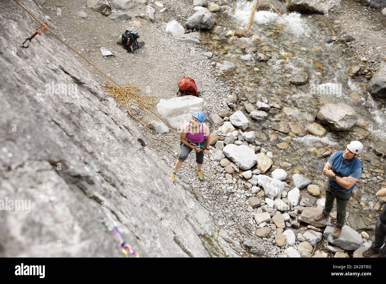 Female belayer holding rock climbing safety rope at base of rock Stock ...