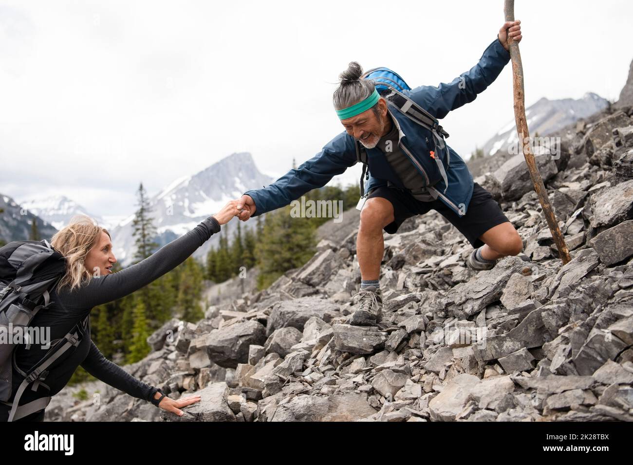 Couple holding hands climbing mountain hi-res stock photography and ...