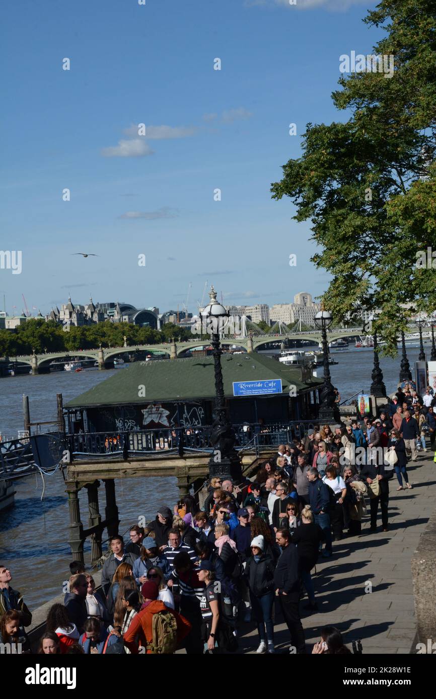 Mourners queue along the south bank of the Thames opposite the Houses ...