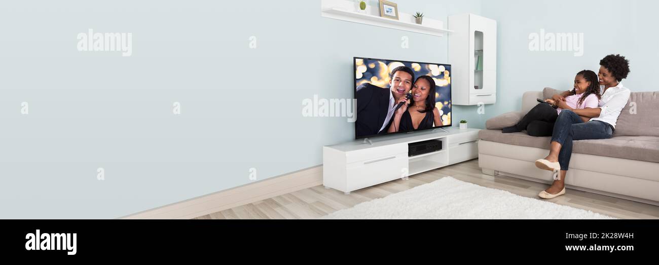 African American Family Watching TV In Living Room Stock Photo - Alamy