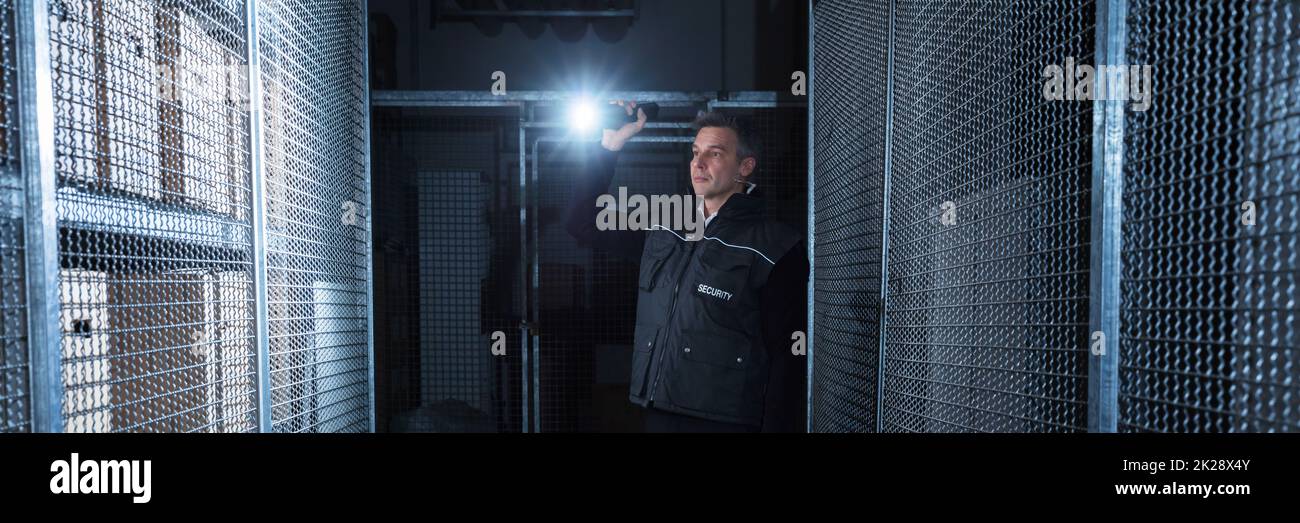 Security Guard With Flashlight At Night In Warehouse Stock Photo - Alamy