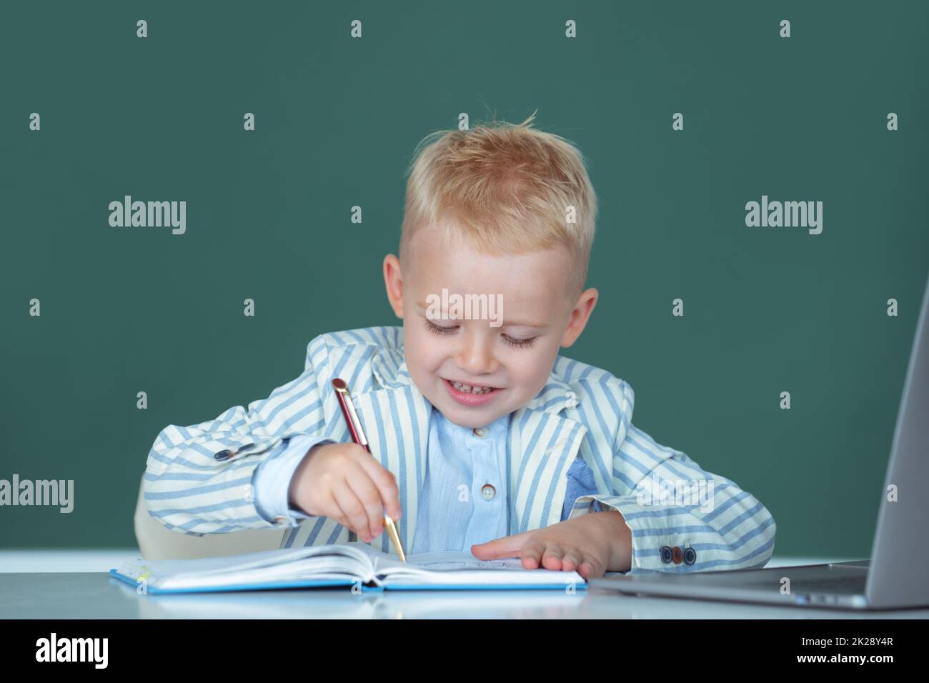 Funny face of little student of primary school study in classroom at ...