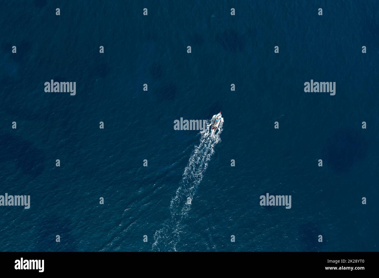 Small fishing boat in the deep blue sea. Overhead view Stock Photo - Alamy