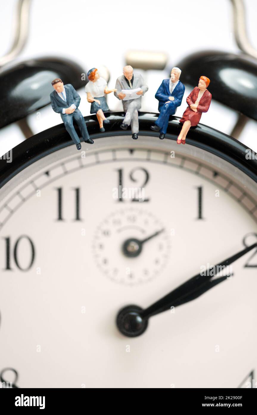 Business team sitting on top of the giant clock Stock Photo - Alamy