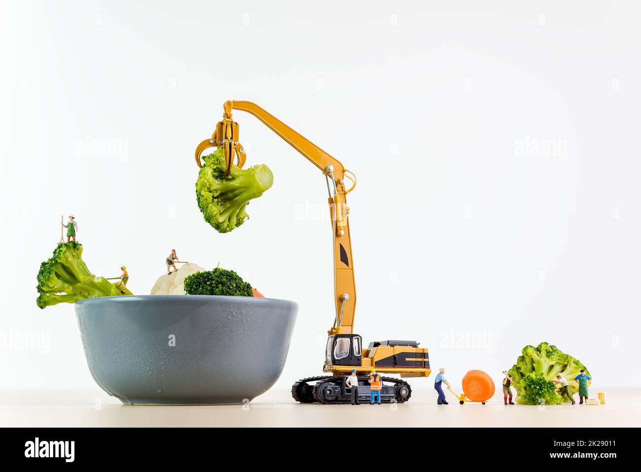 Miniature people making salad. Cooking concept Stock Photo - Alamy