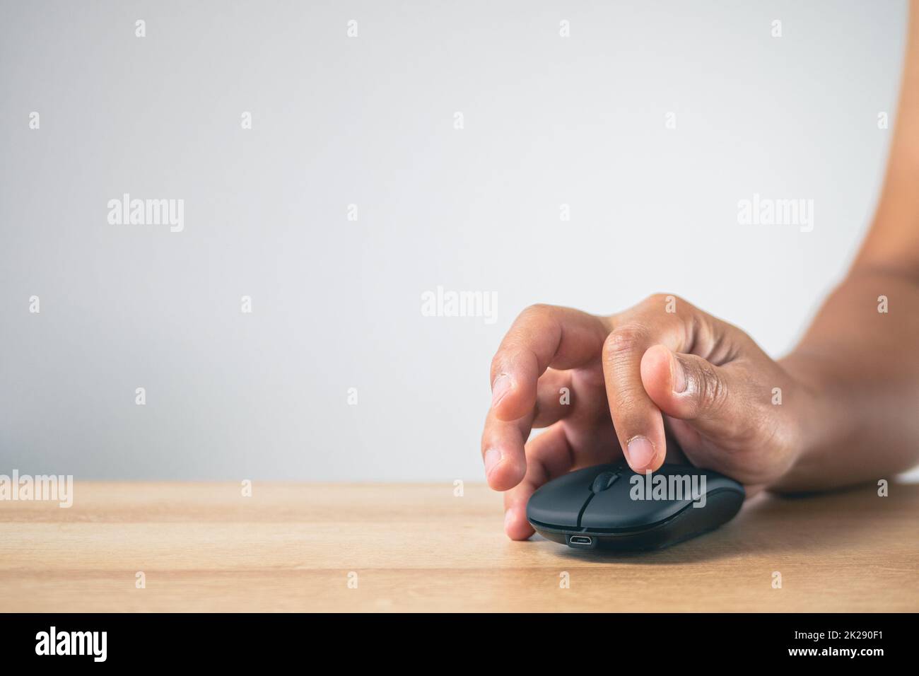 The man uses a mouse until his fingers pain. Office syndrome concept ...