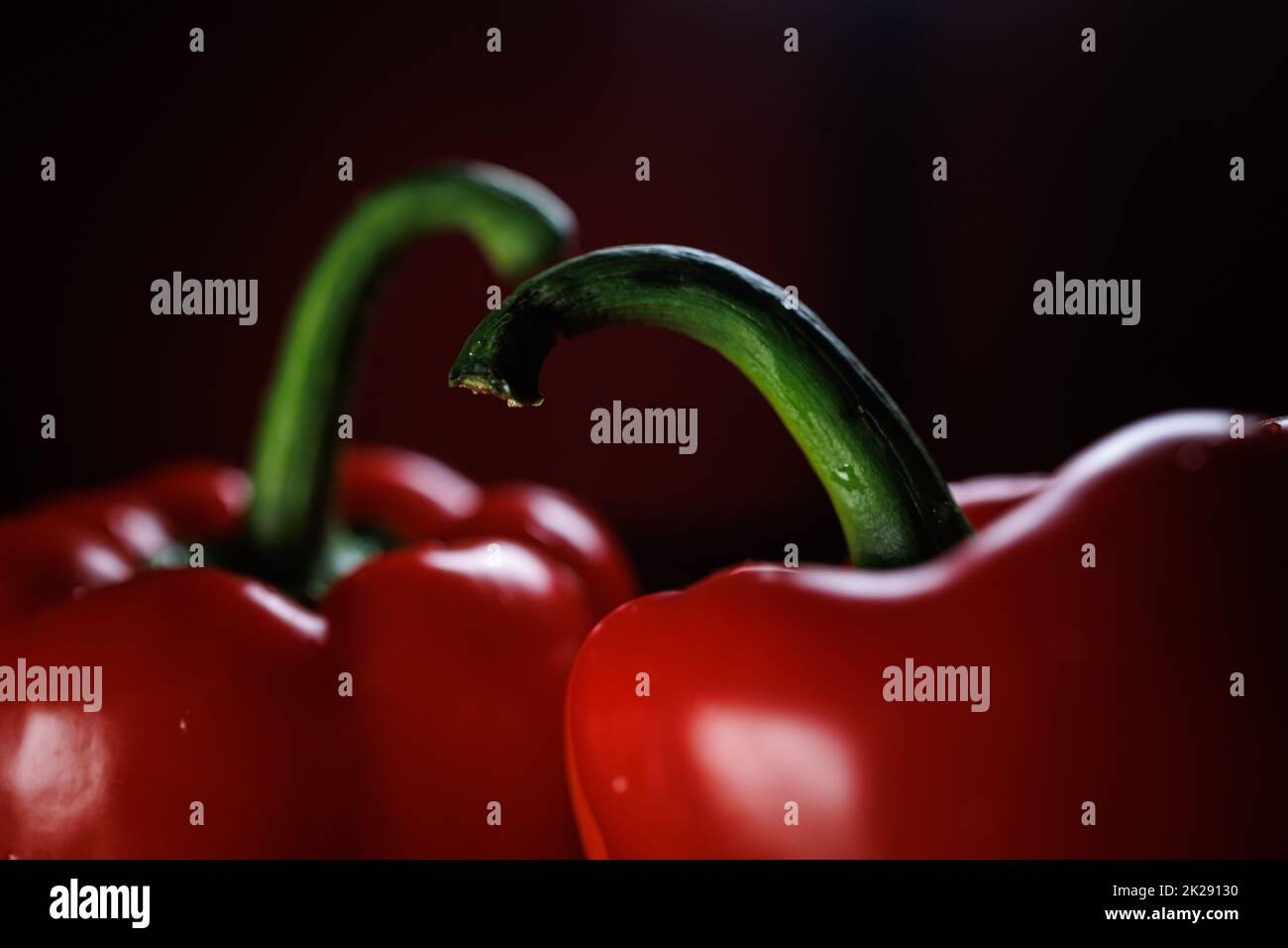 Two red pepper in bowl dark backround Stock Photo - Alamy