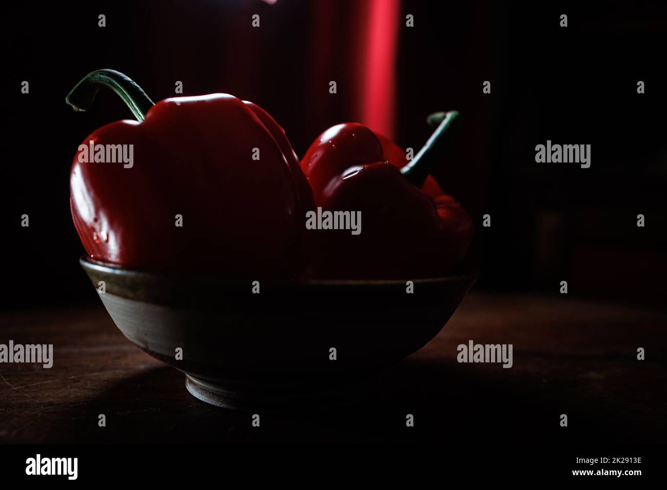 Two red pepper in bowl with red backround Stock Photo - Alamy