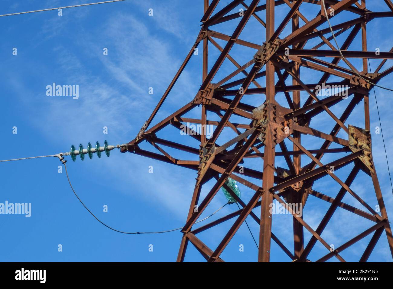 Supports high-voltage power lines against the blue sky with clouds ...