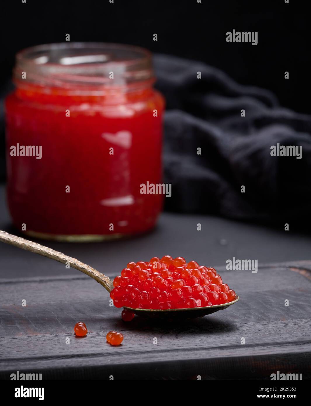 fresh grainy red caviar in a glass jar on a wooden table Stock Photo ...