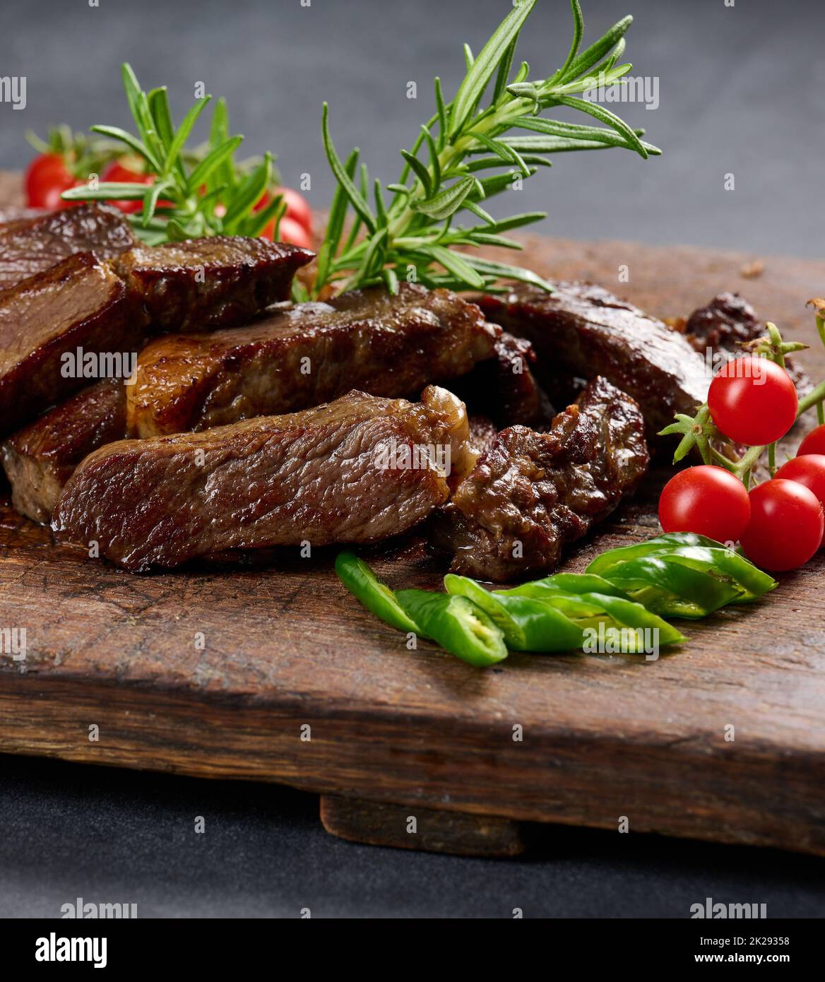roasted piece of beef ribeye cut into pieces on a vintage brown ...