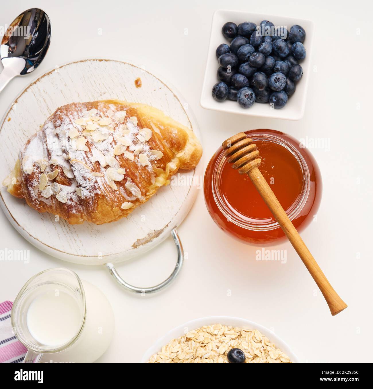 Morning breakfast, raw oatmeal flakes in a ceramic plate, milk in a ...