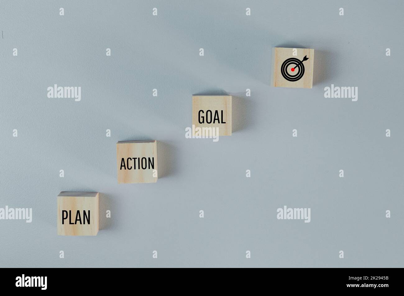 Wooden cubes with plan action goal symbol on background and copy space ...