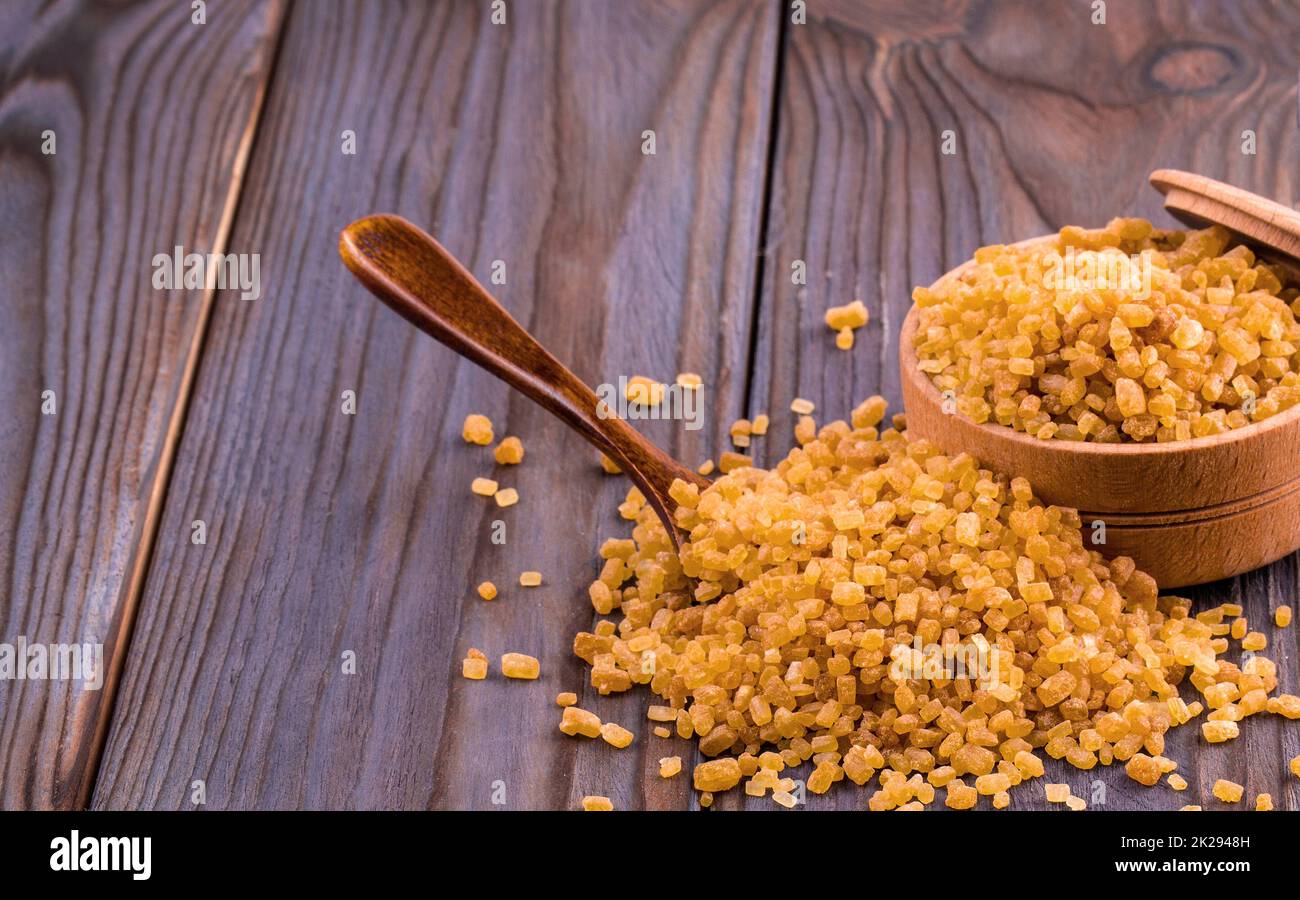 Cane sugar in a wooden cup on a wooden table Stock Photo - Alamy
