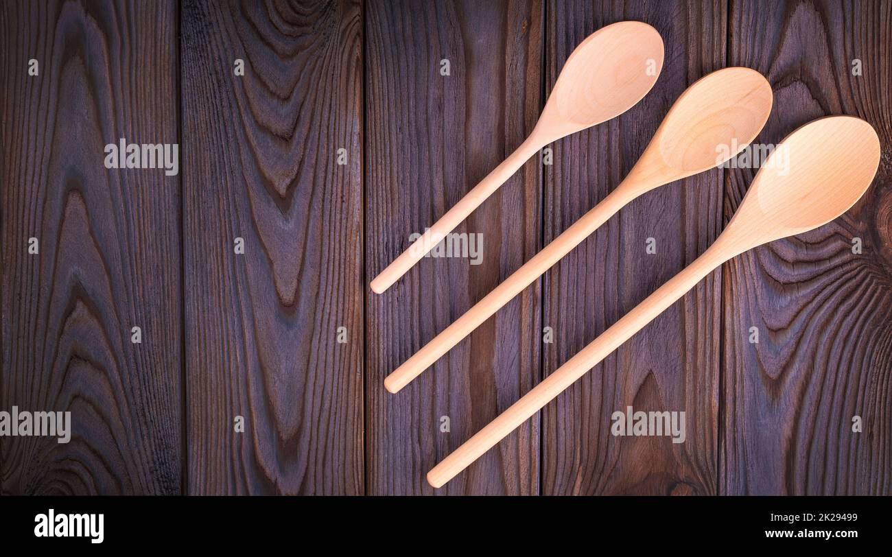 Three wooden spoons on a dark wood table Stock Photo - Alamy