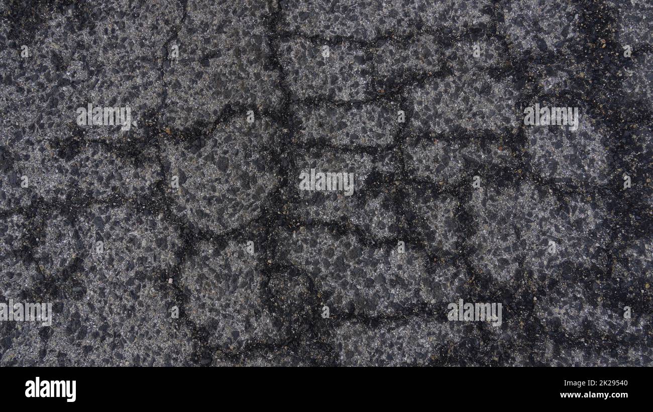 Top view of an old asphalt road in wet cracks. Worn road with cracks ...