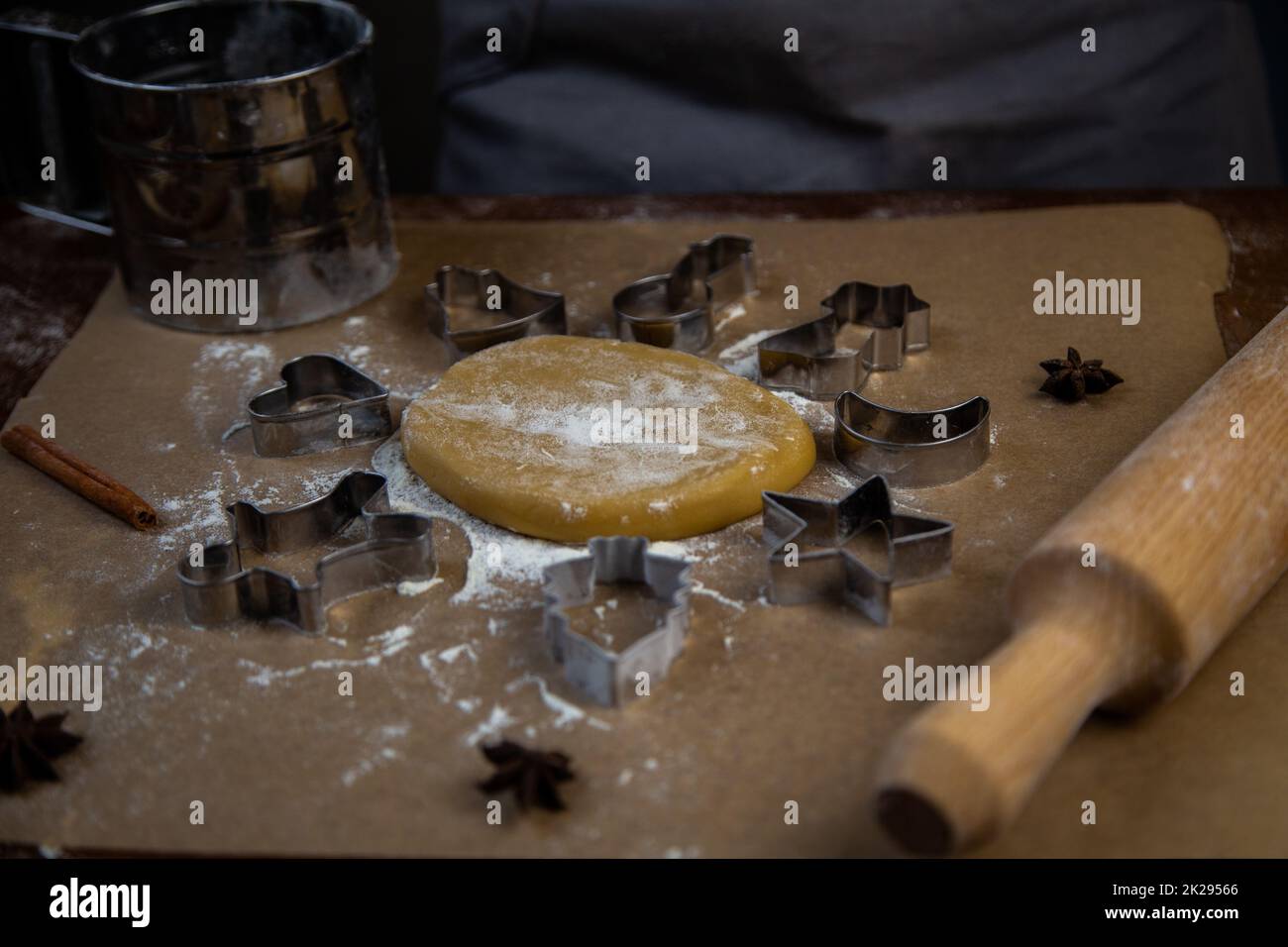 There is a dough on the parchment, around which there are cookie ...