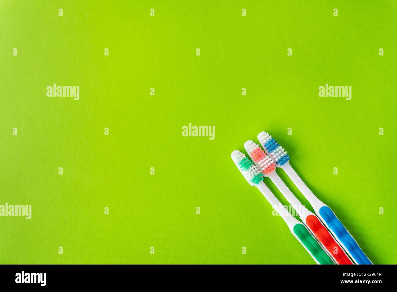Multi-colored toothbrushes on a green background, the concept of dental ...