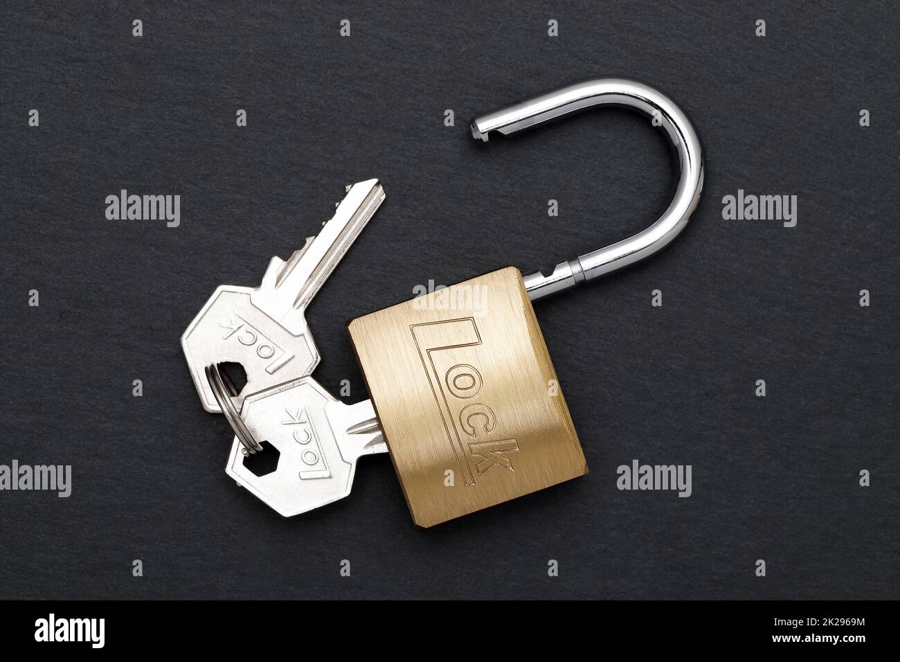 Steel padlock with key on a black background Stock Photo - Alamy