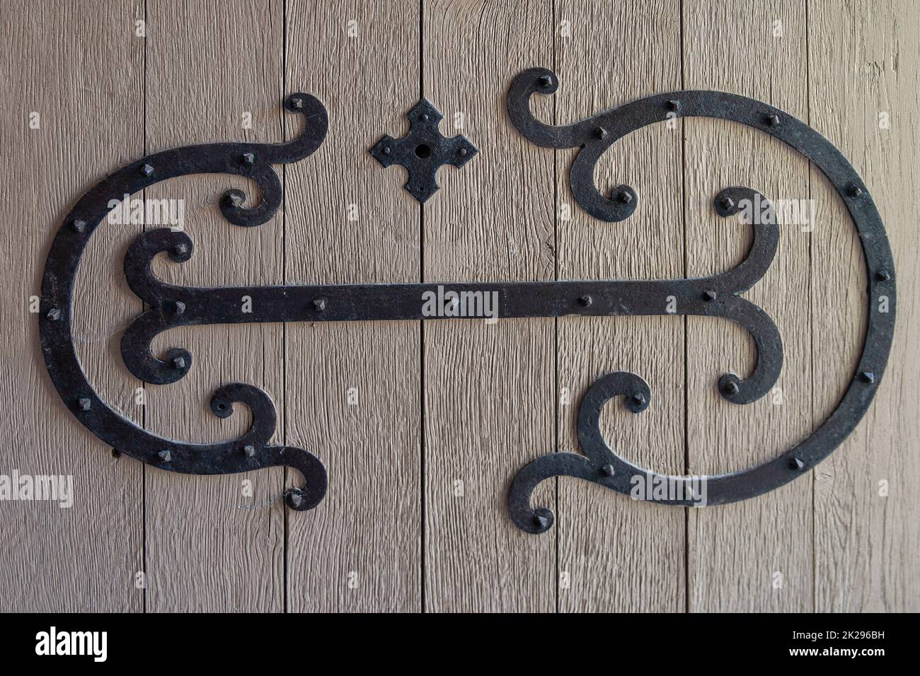 Detail of an old red wooden door with wrought iron decoration in the ...