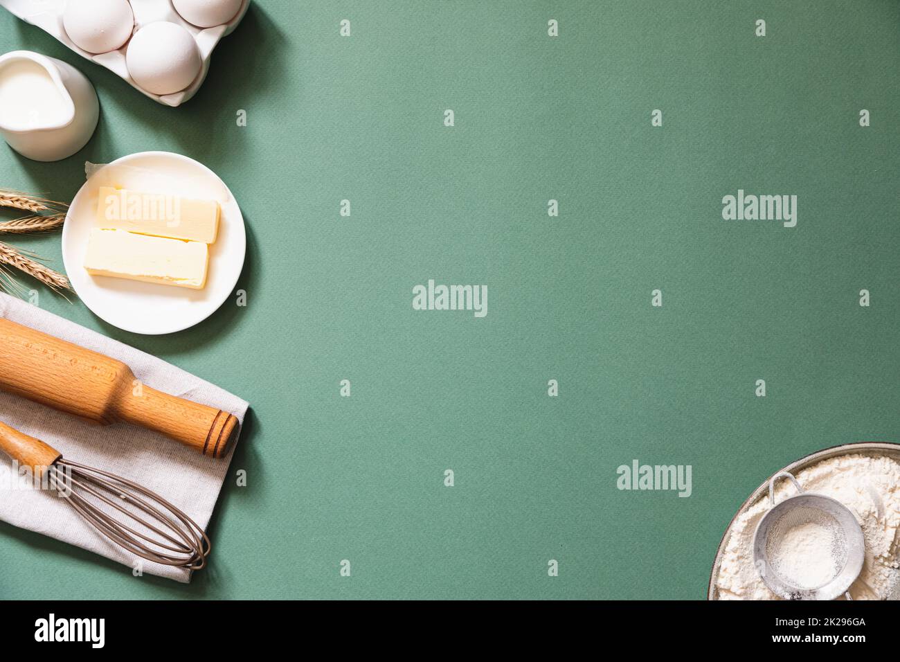Frame of food ingredients for baking on a green pastel background ...