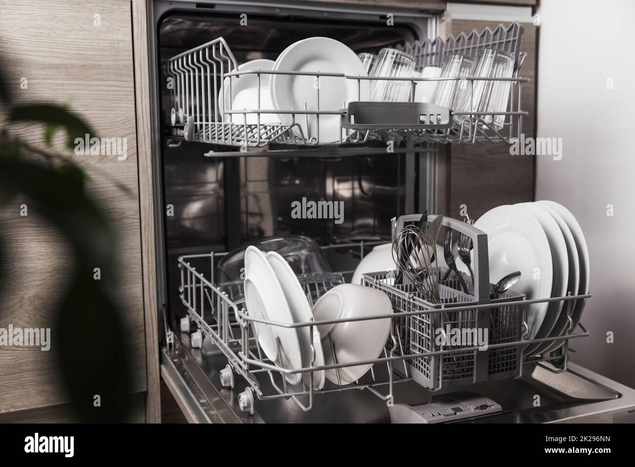 Open dishwasher with clean utensil inside, cutlery, glasses, dishes at ...