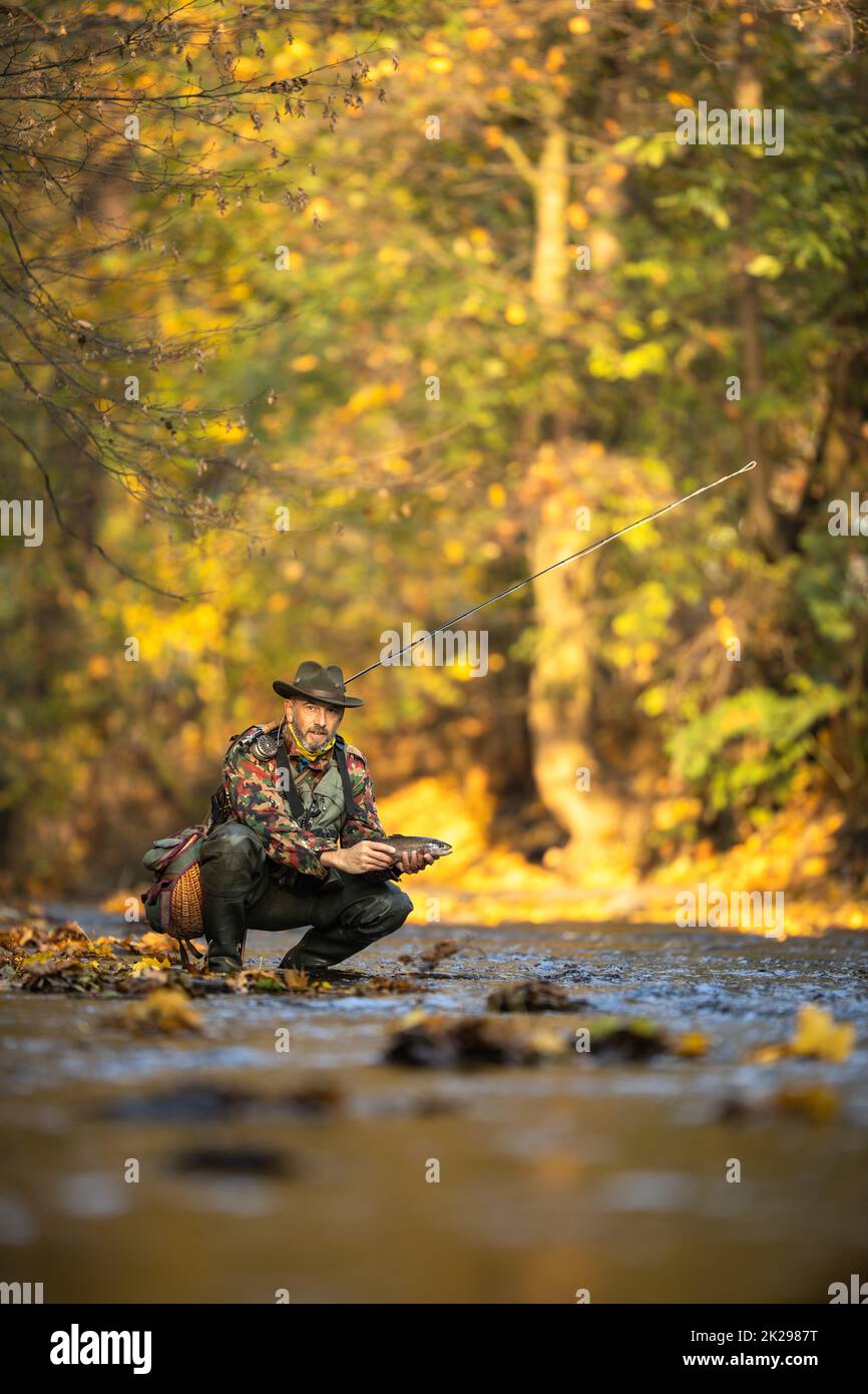 Close-up view of the hands of a fly fisherman holding a lovely trout ...