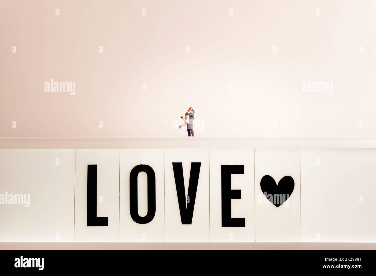 Loving couple hugging on top of a large LOVE sign Stock Photo - Alamy