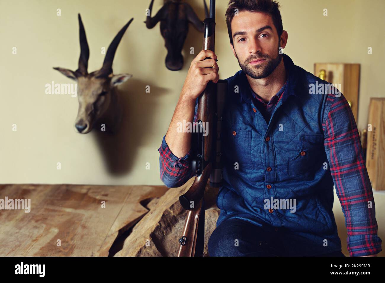 Hes a skilled hunter. Portrait of a hunter sitting in front of his ...