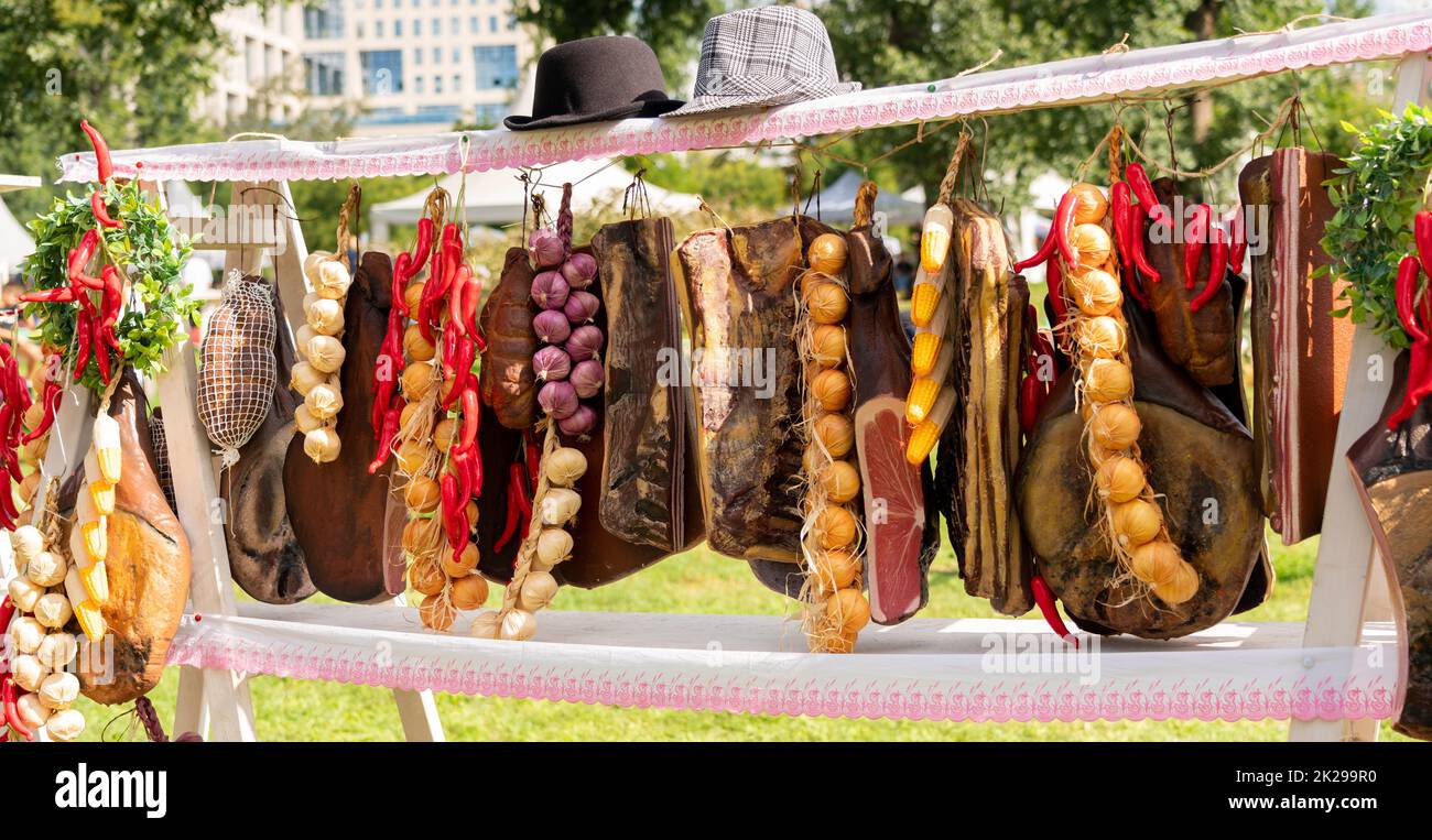 Market display with large pieces of meat, bacon, jamon and other ...