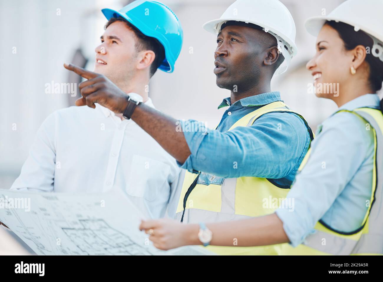 Architect at construction site, discussion on blueprint or plan for ...