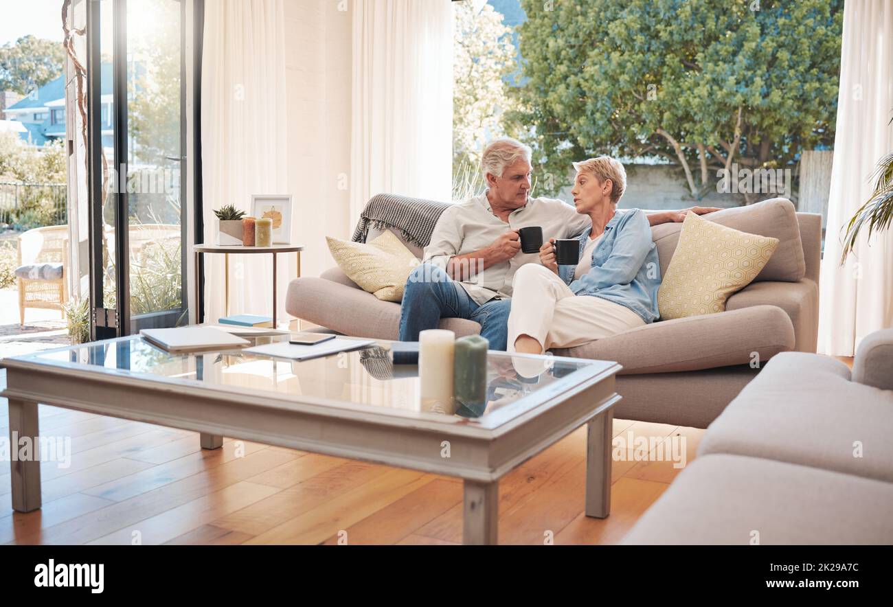 Relax, retirement and coffee with elderly couple bonding on a sofa, enjoying a peaceful morning ...