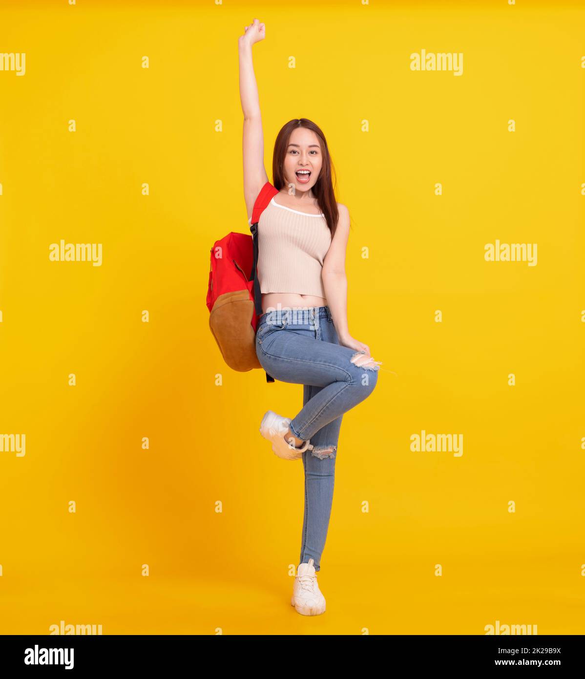 Happy student girl having fun isolated over yellow Stock Photo - Alamy