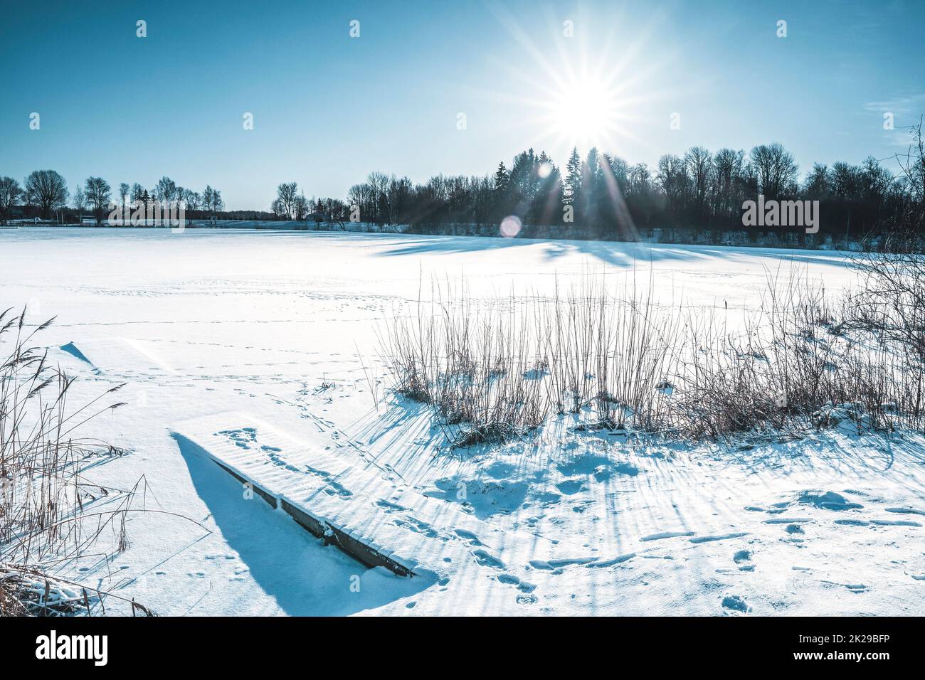 Wooden footbridge under snow on frozen lake Stock Photo - Alamy