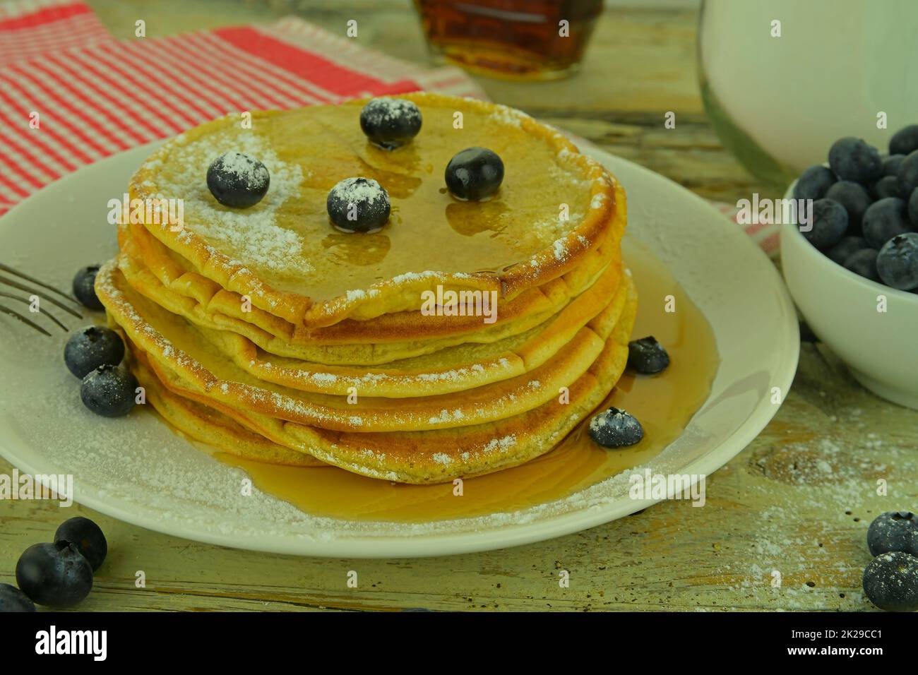 Delicious pancakes with fresh blueberries and syrup on a rustic wooden ...