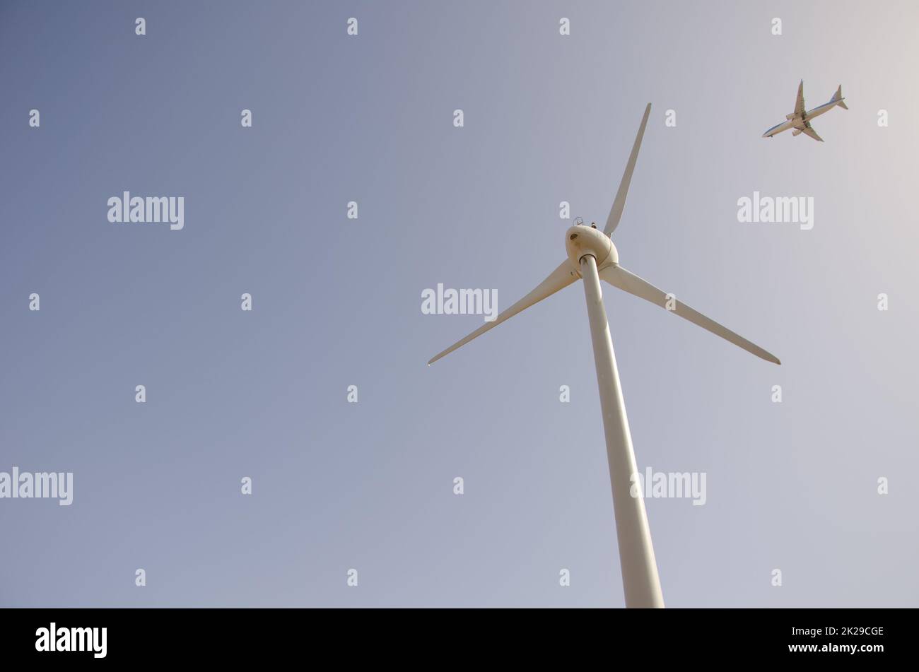 Airplane in flight and wind turbine Stock Photo - Alamy