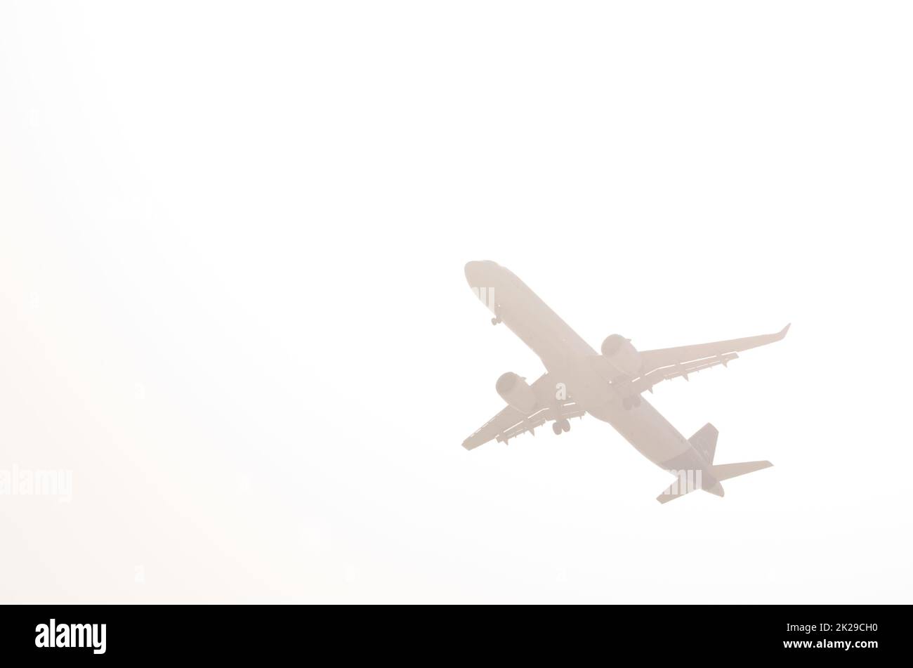 Airplane flying against the light Stock Photo - Alamy