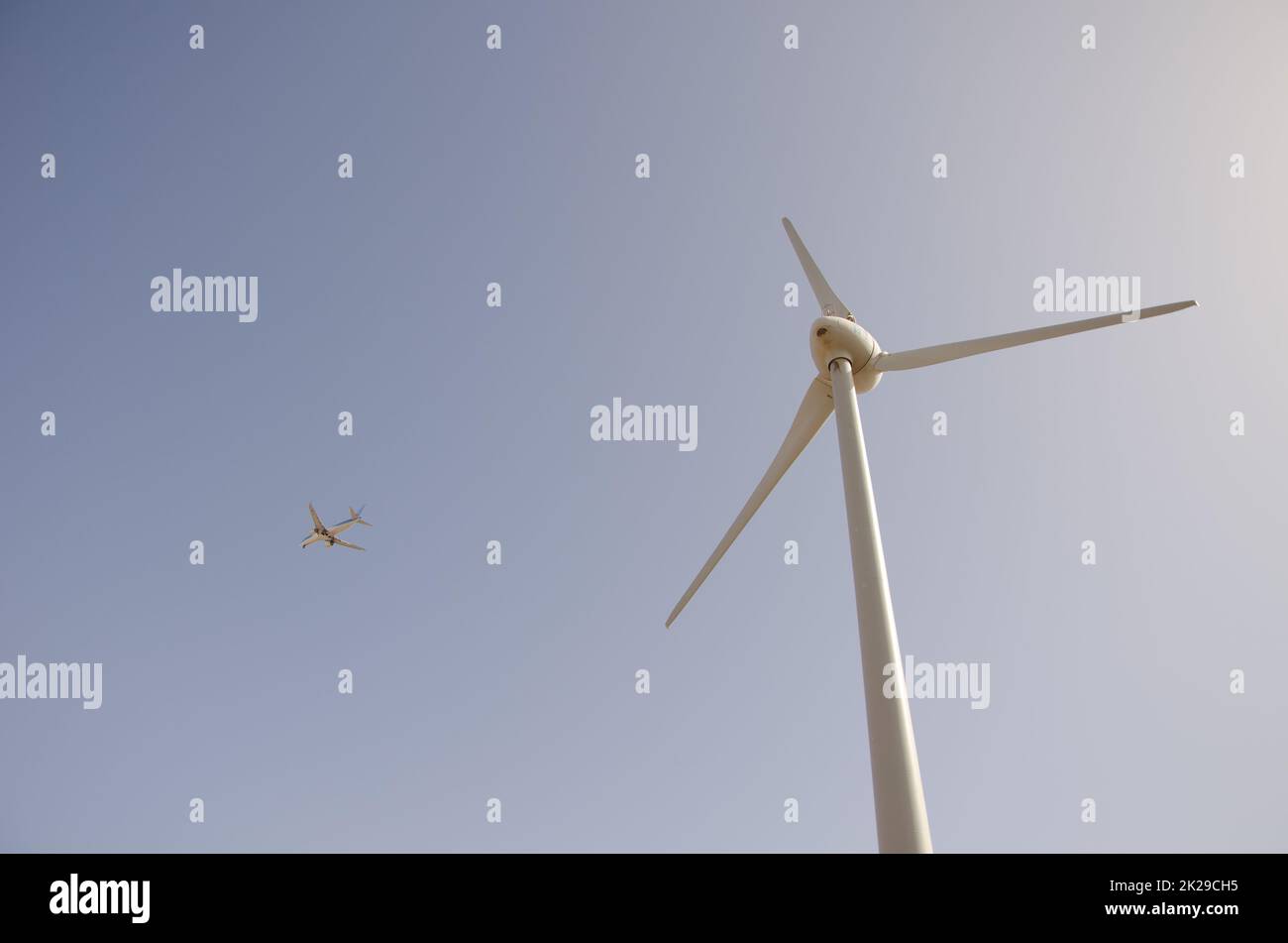 Airplane in flight and wind turbine Stock Photo - Alamy