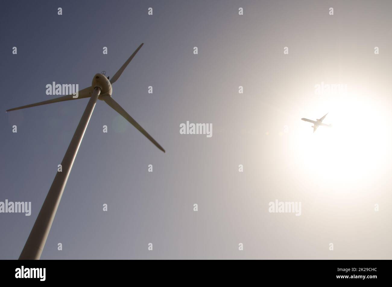 Airplane and wind turbine against the light Stock Photo - Alamy