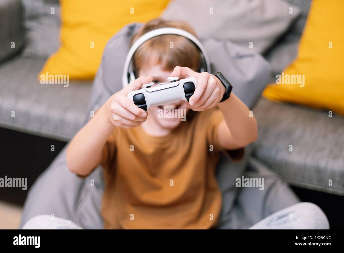 Teen boy with headphones and joystick playing video game console Stock ...