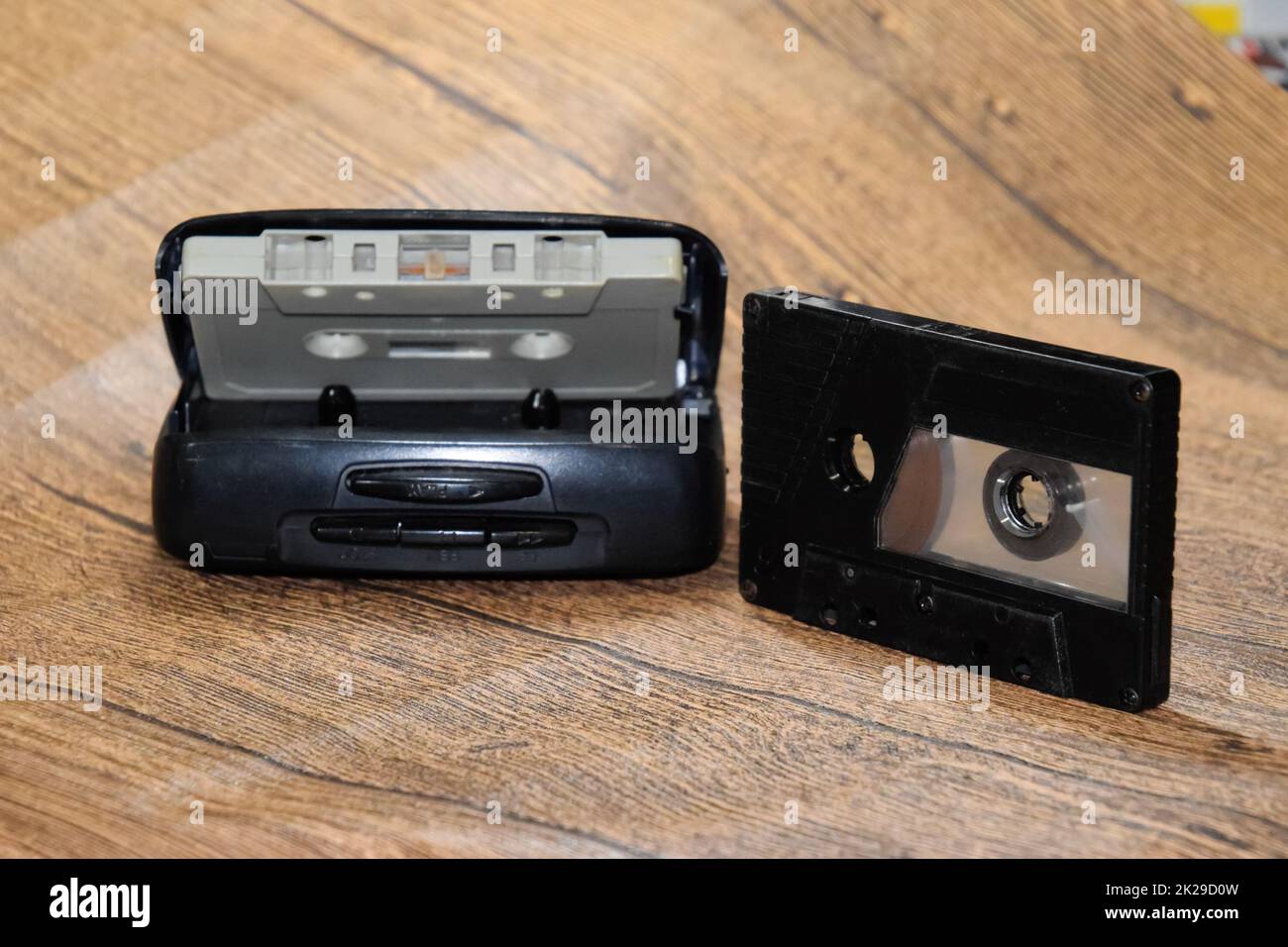 Retro audio cassettes next to a portable player to play compact ...