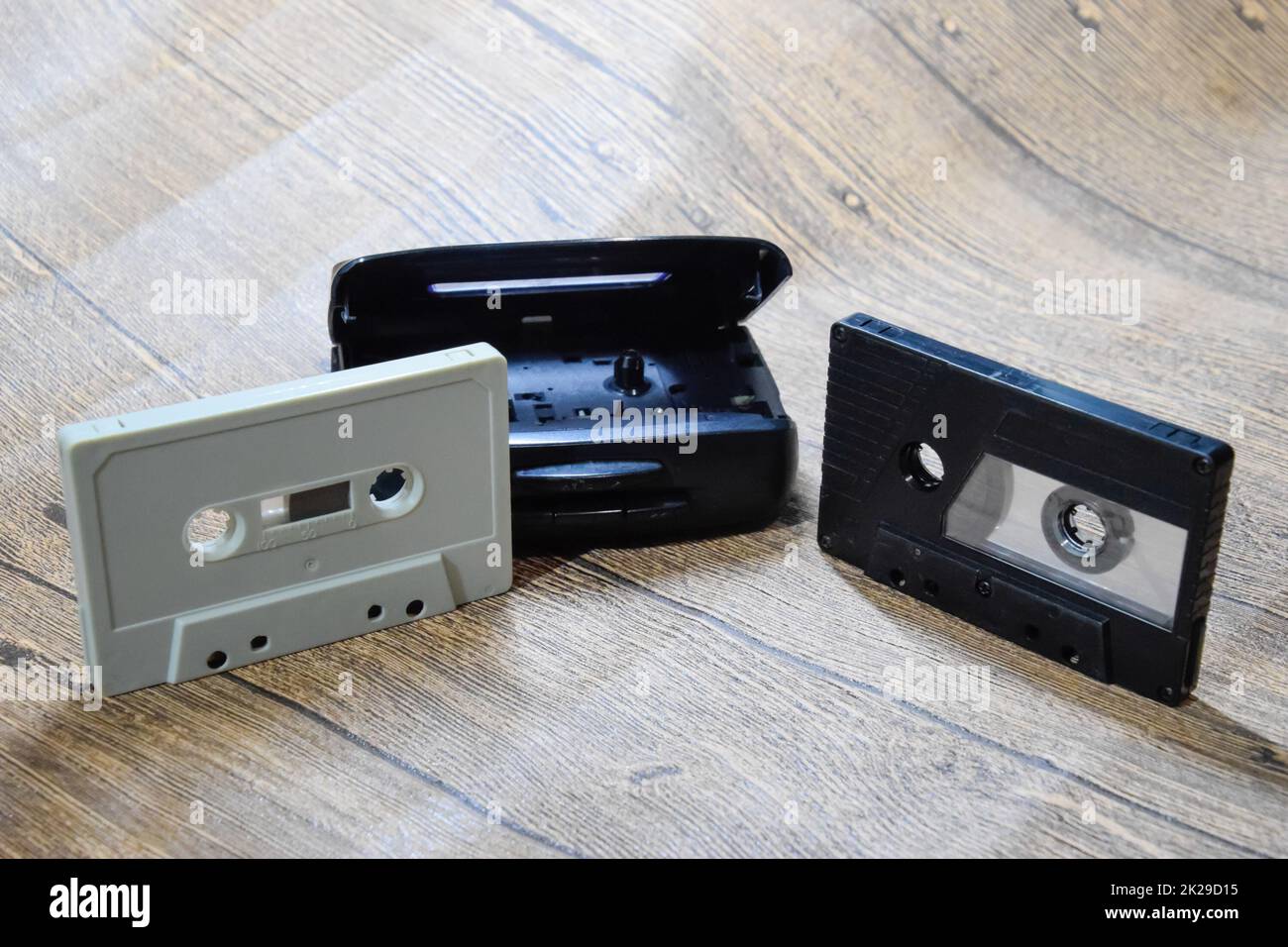 Retro audio cassettes next to a portable player to play compact ...