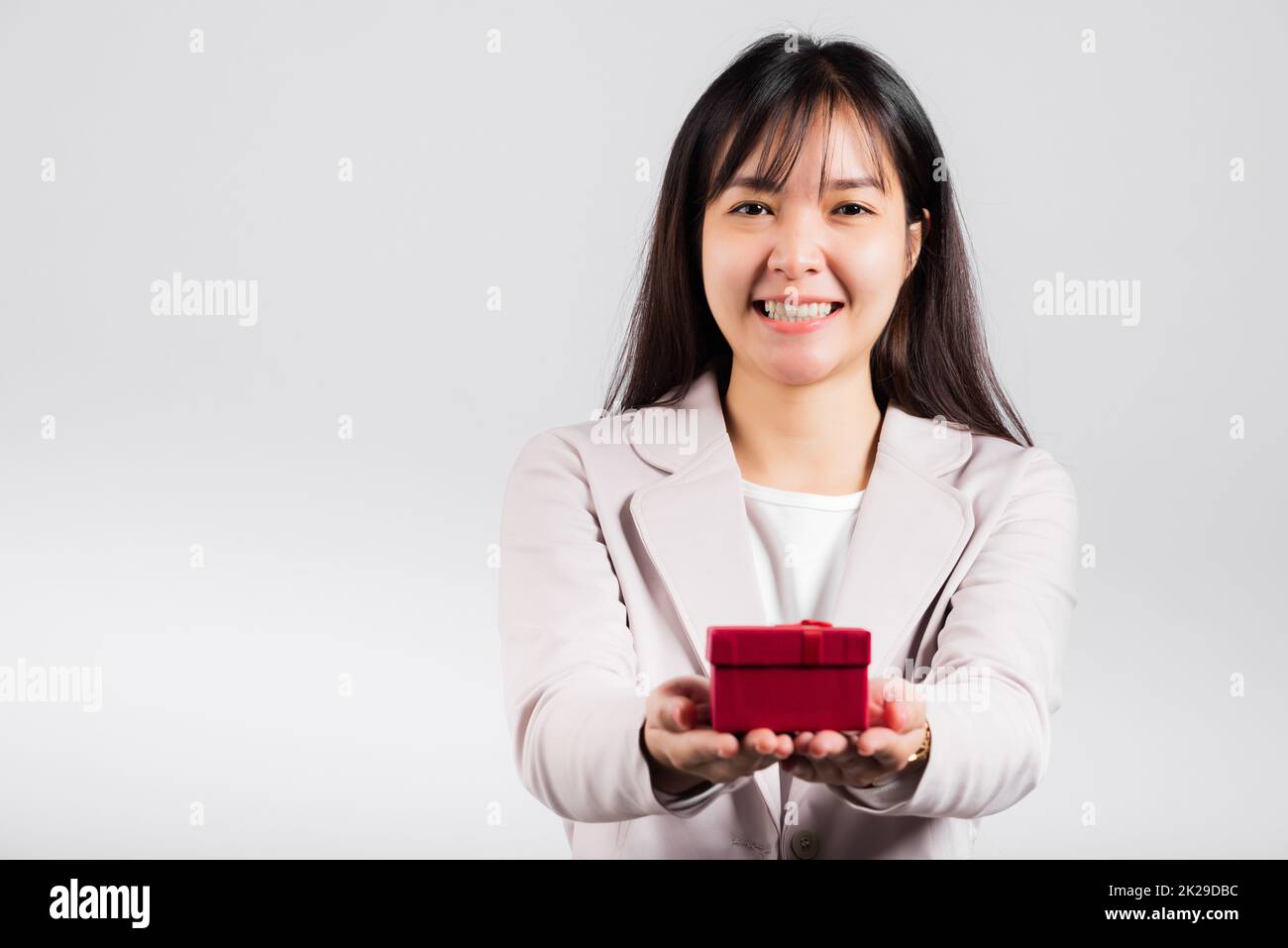 Smiling woman confidence holding red gift box on hands palm isolated ...