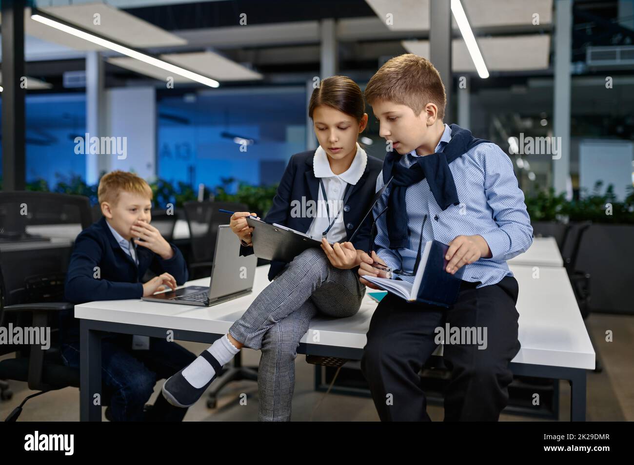 Little children coworker discussing project in office Stock Photo - Alamy