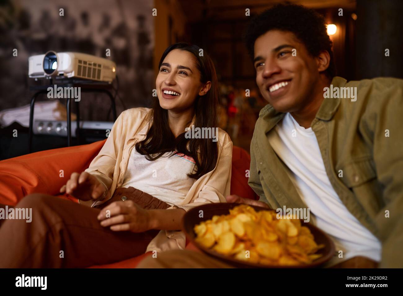 Family couple watching television projector at home Stock Photo - Alamy