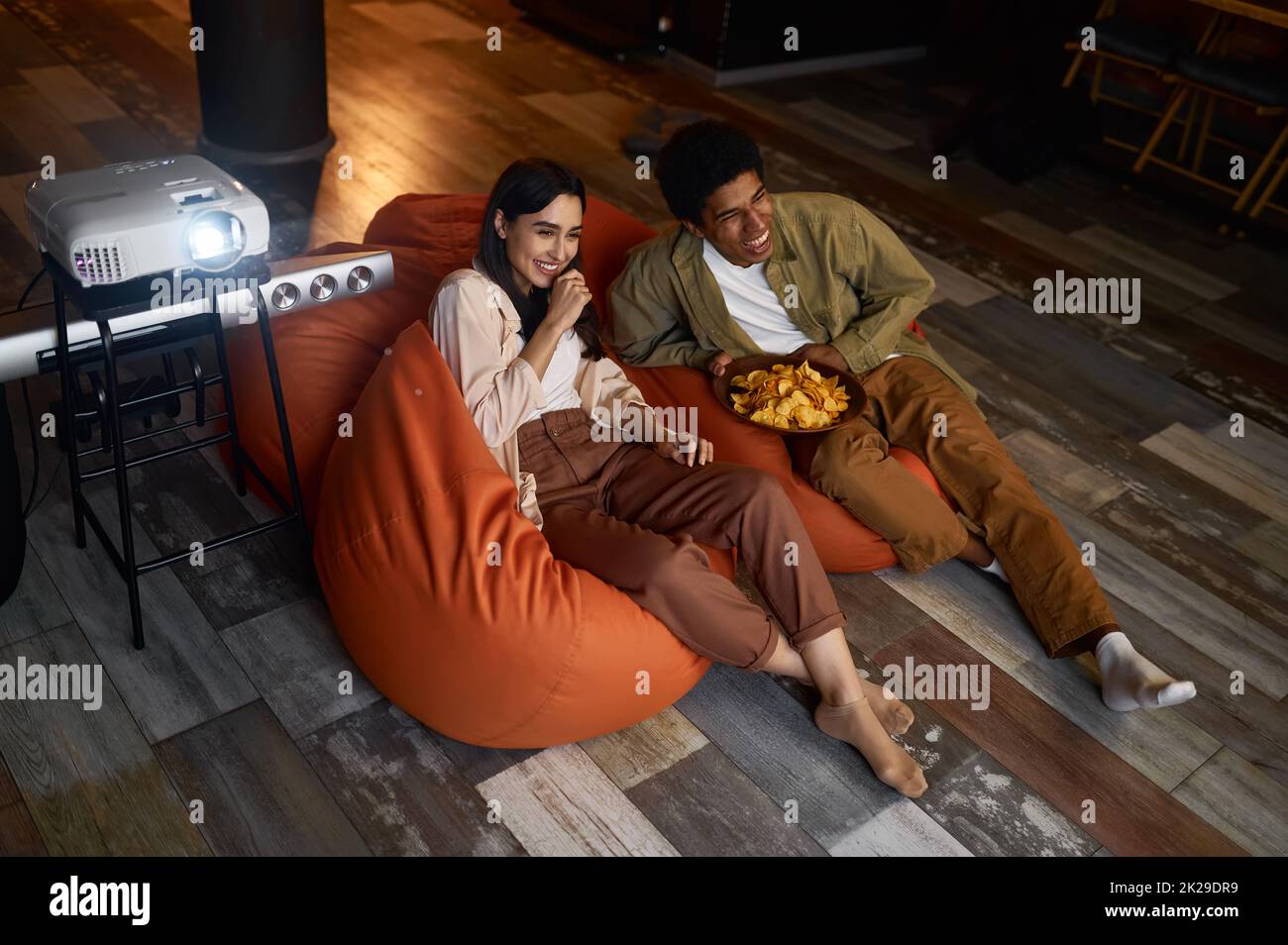 Family couple watching television projector at home Stock Photo - Alamy