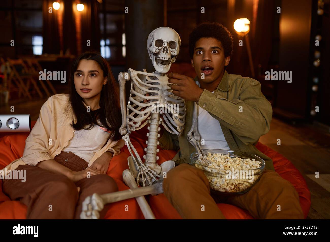 Funny couple and skeleton watching studio projector Stock Photo - Alamy