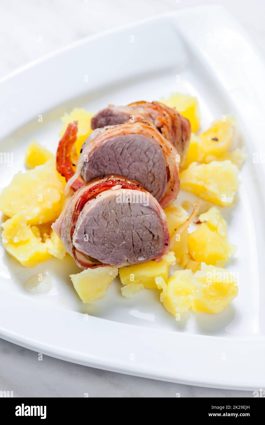pork roll wrapped in bacon with potatoes Stock Photo - Alamy